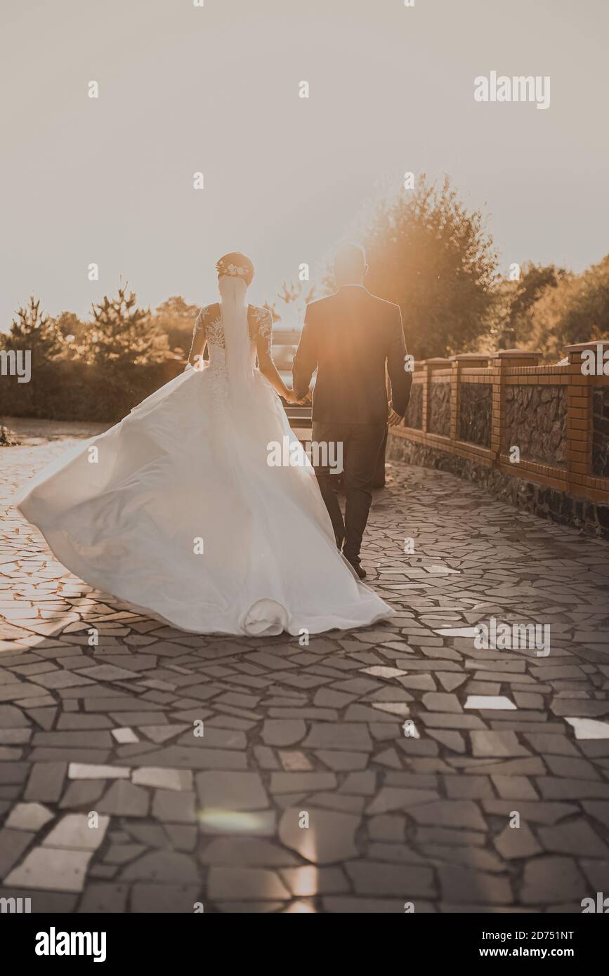 The wedding couple runs away into the sunset Stock Photo - Alamy
