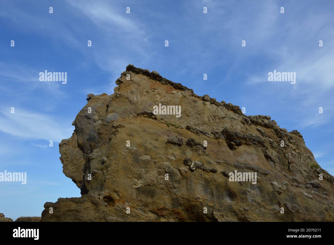 Low-angle shot of a massive rock cliff on the blue sky background Stock ...