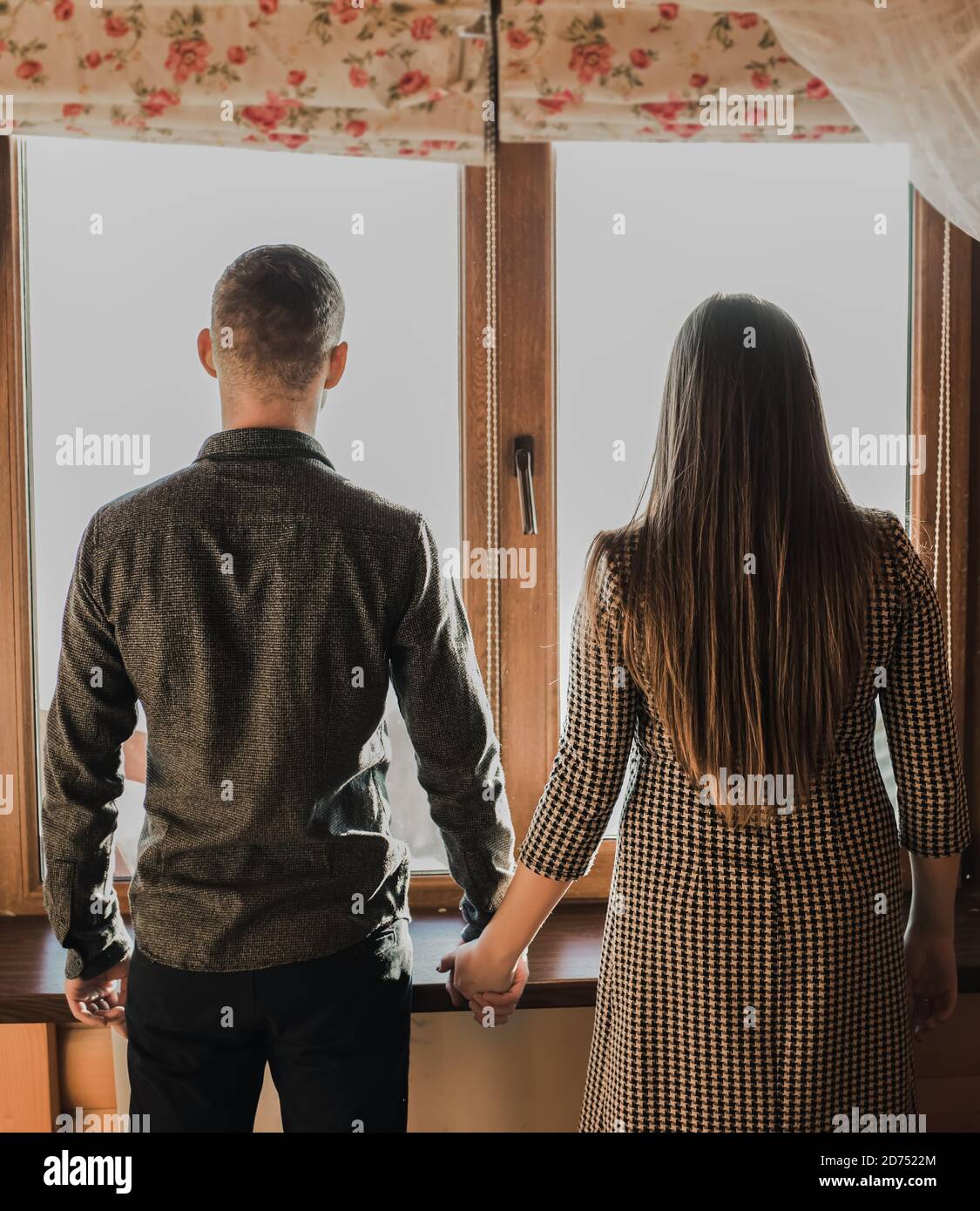 The guy and the girl are holding hands couple standing backwards ...