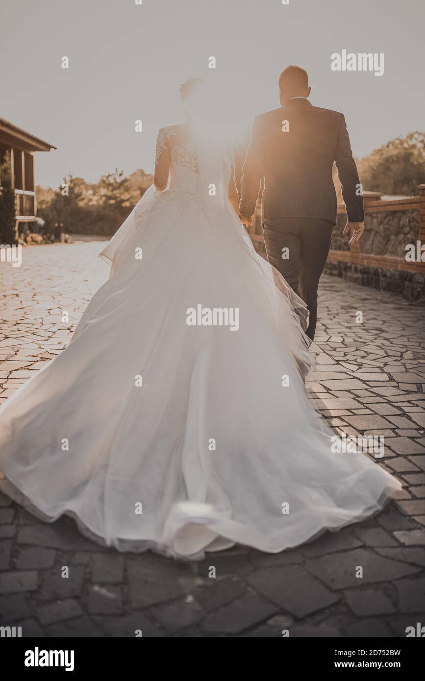 The wedding couple runs away into the sunset Stock Photo - Alamy