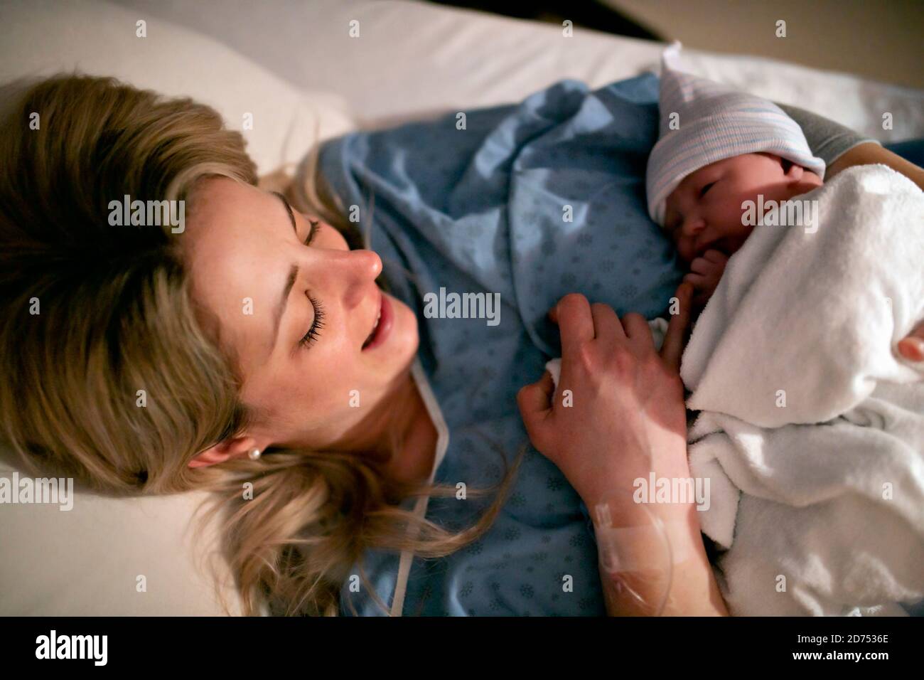 Mother rest with her newborn baby relieve in bed immediately after a ...