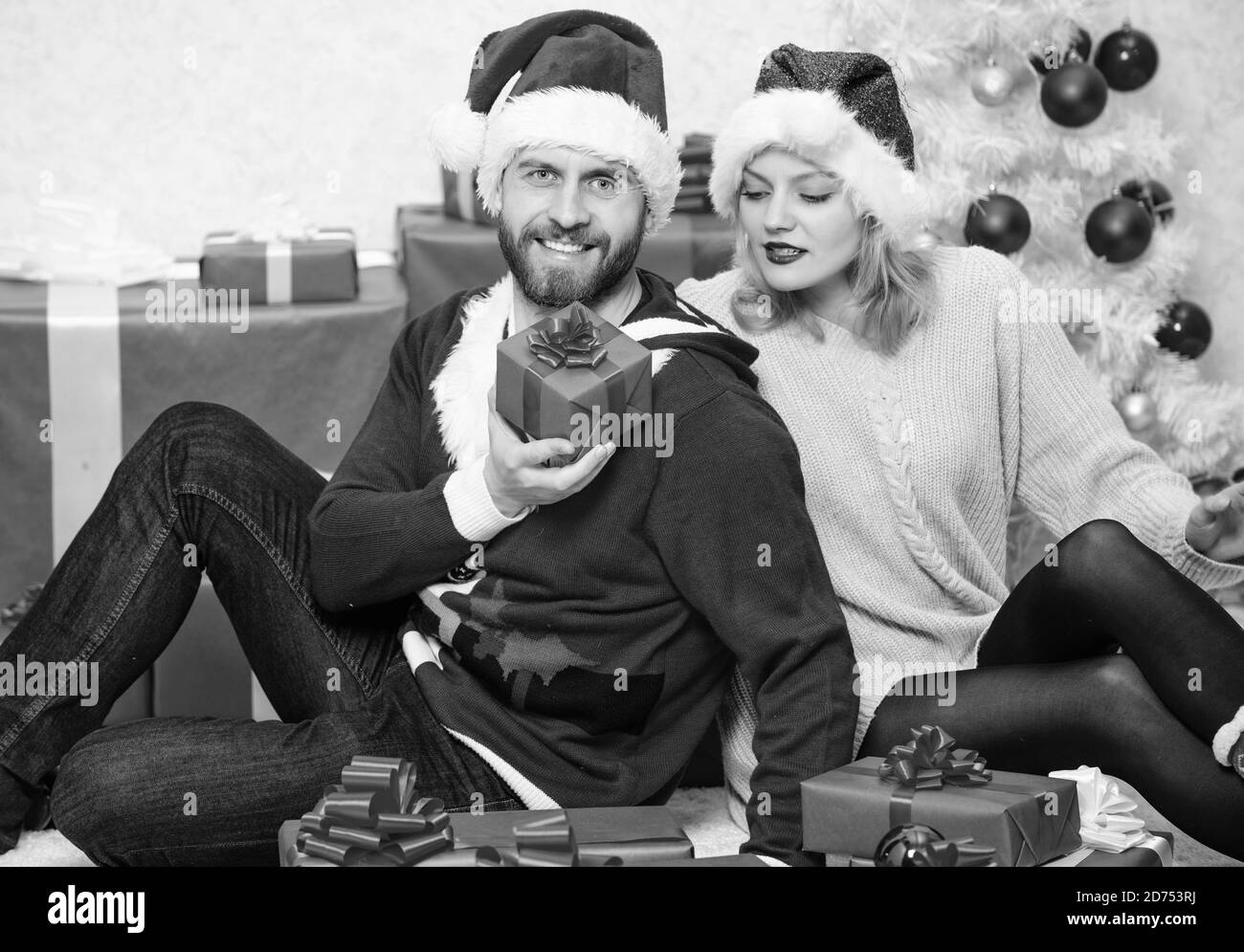 Christmas is time for giving. Loving couple cuddle smiling while ...