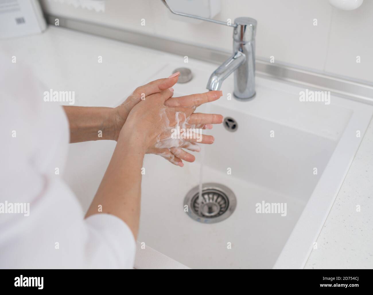 Pretty doctor washing her hands with soap Stock Photo - Alamy
