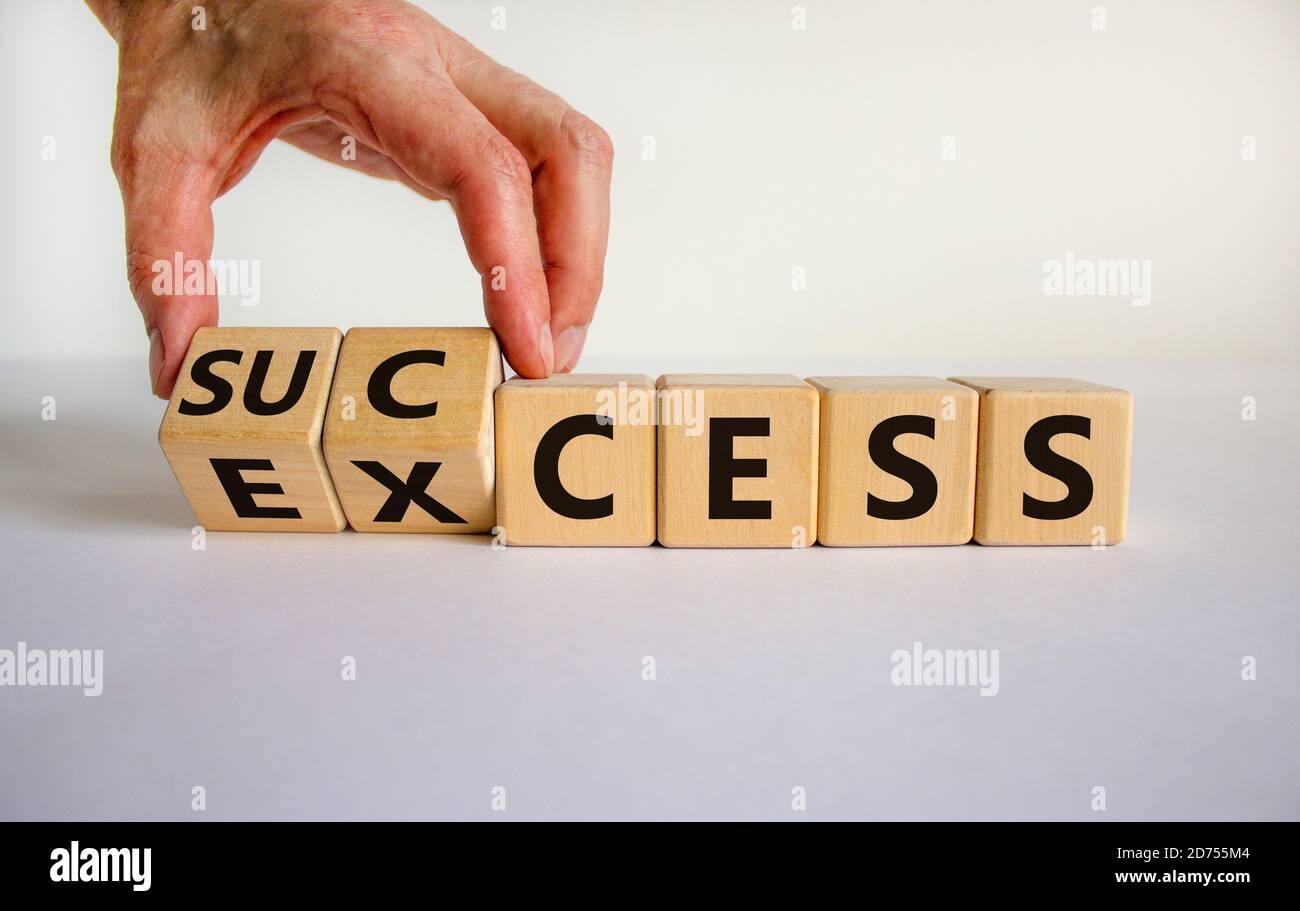 Hand turns wood cubes and change the words 'success' to 'excess' or ...