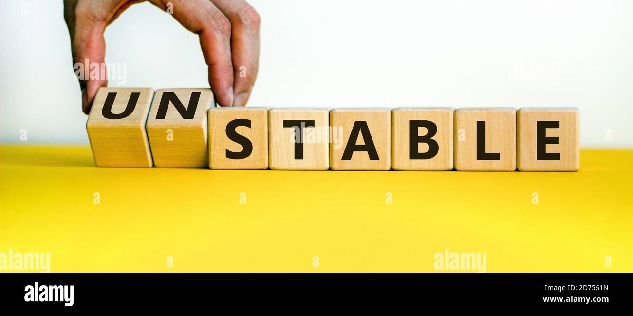 Hand flips a cube and changes the word 'unstable' to 'stable' or vice ...