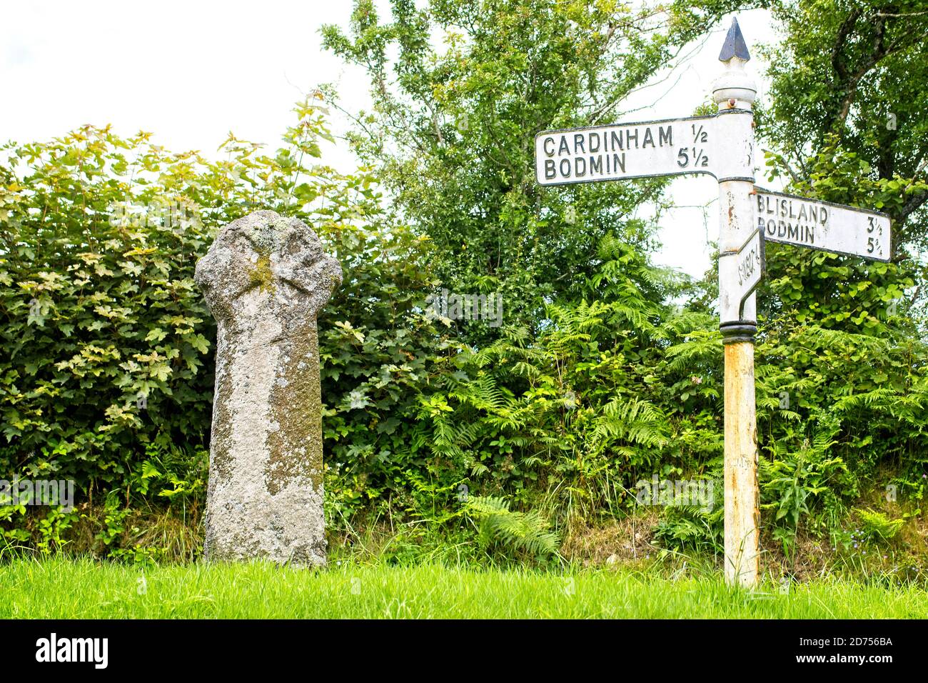 Ancient stone cross and an old 'fingerpost' road sign at a road ...