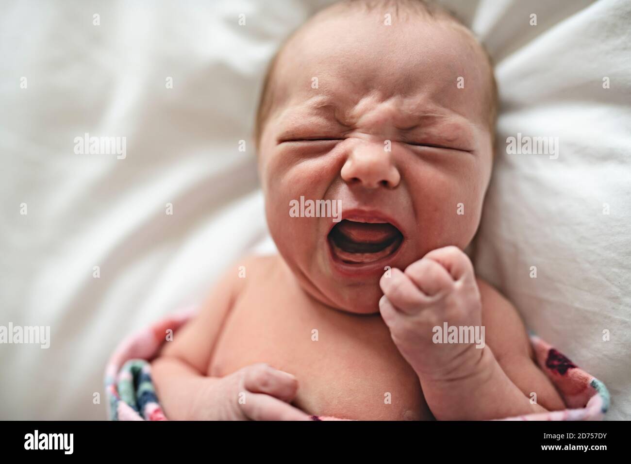 A cute Newborn baby crying in bed Stock Photo - Alamy
