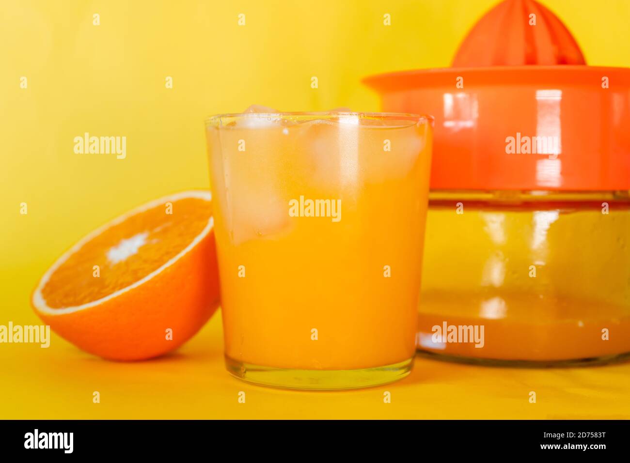 Glass of squeezed orange juice with half orange and a squeezer isolated ...
