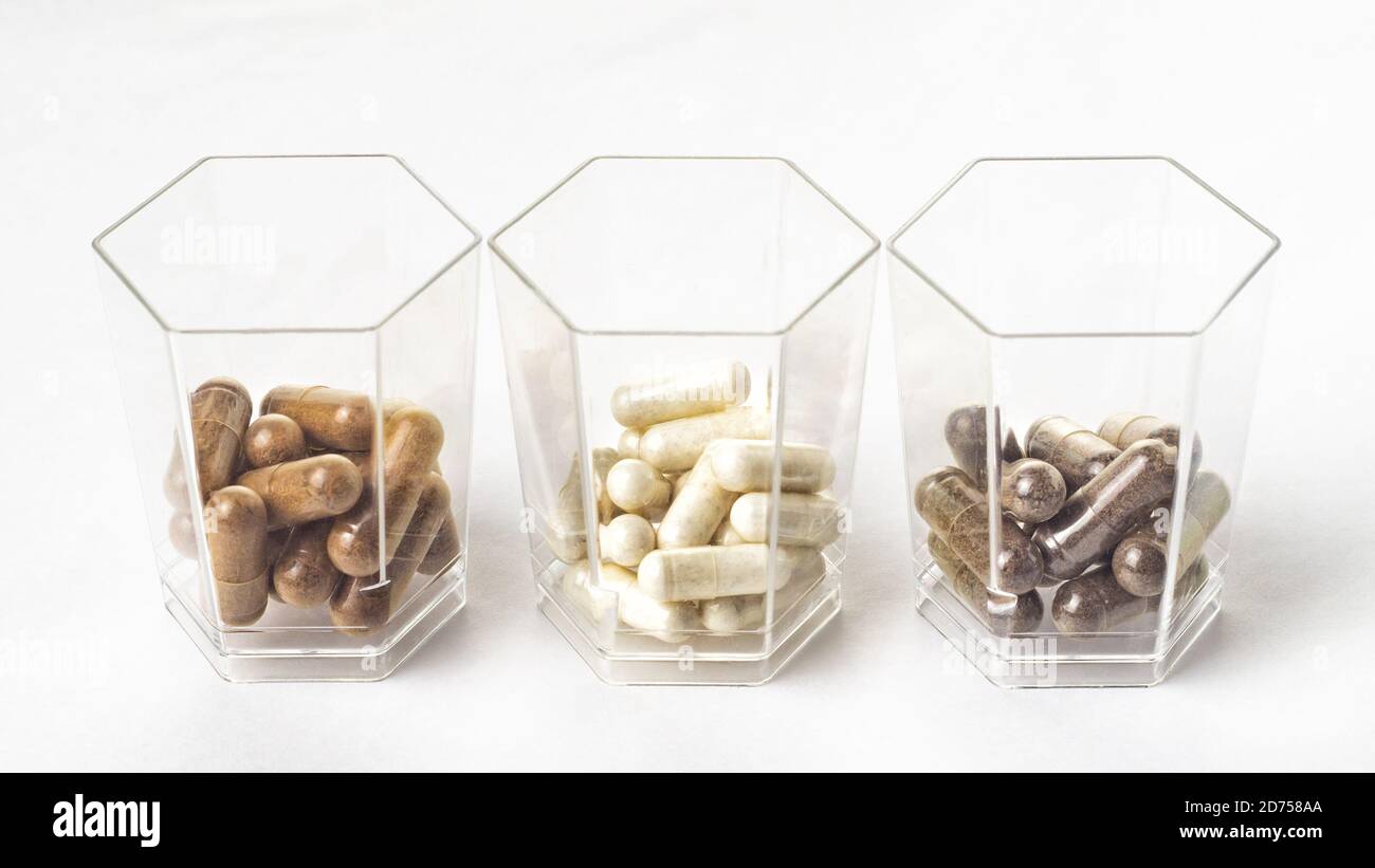 Various medical capsules and tablets in hexagonal transparent jars ...