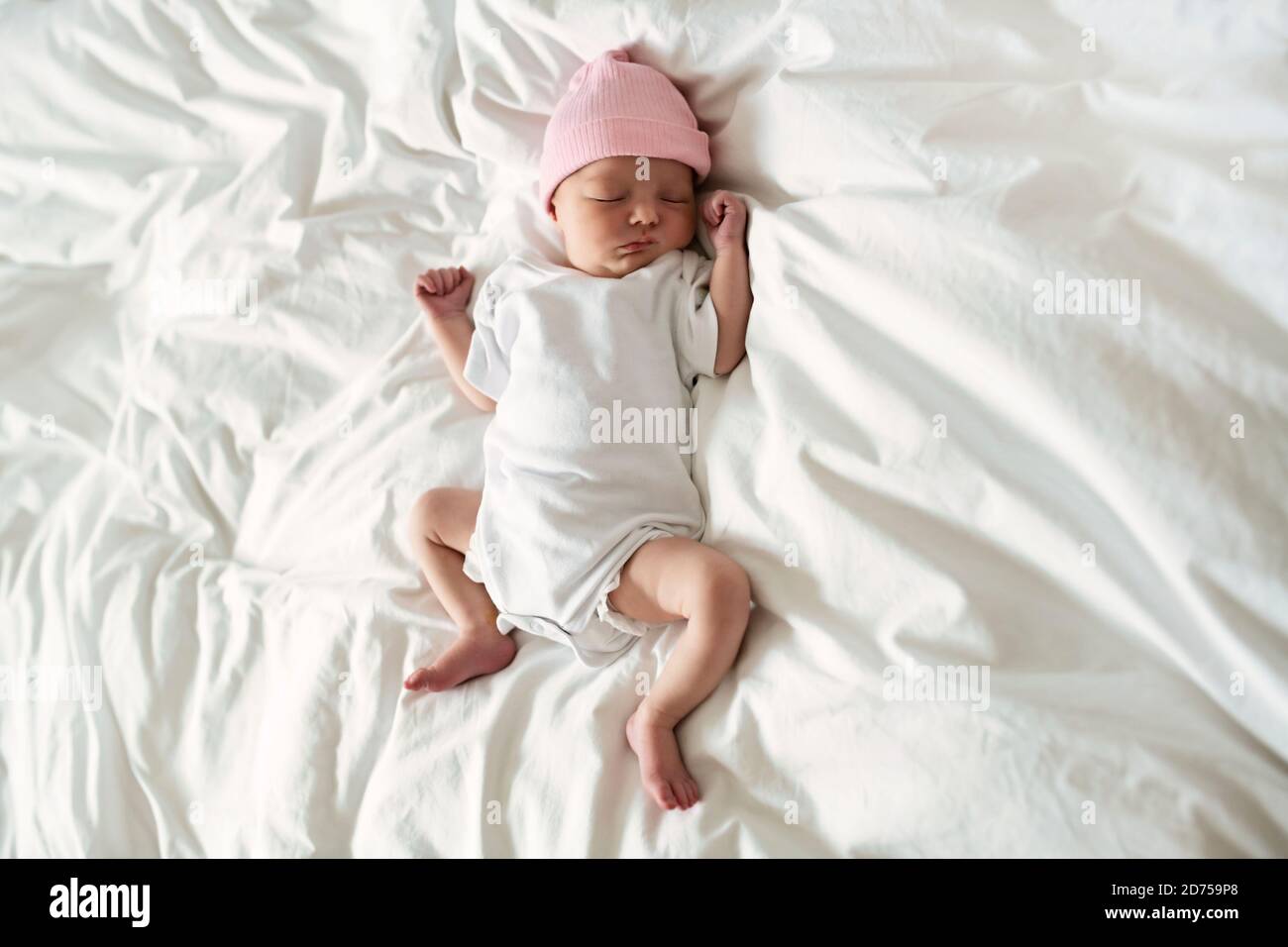 A Sweet newborn baby girl sleeping in white bed Stock Photo - Alamy