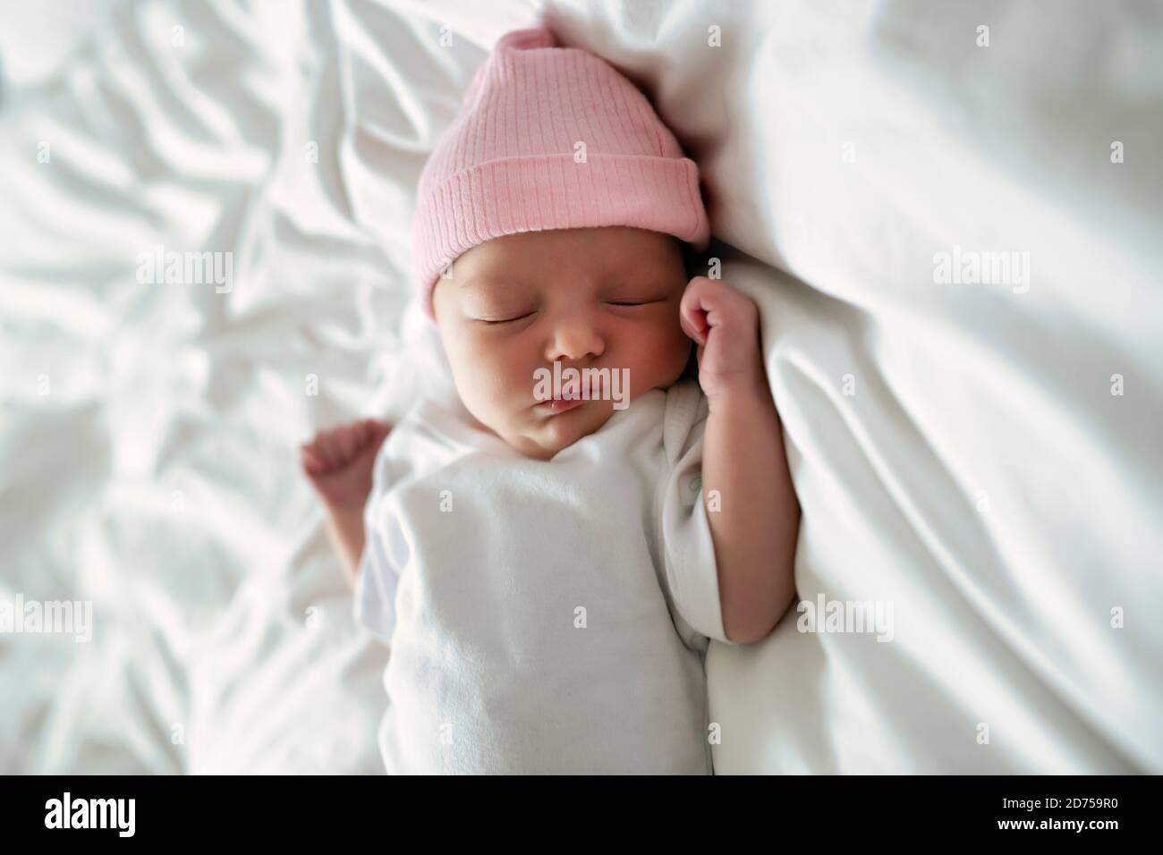 A Sweet newborn baby girl sleeping in white bed Stock Photo - Alamy