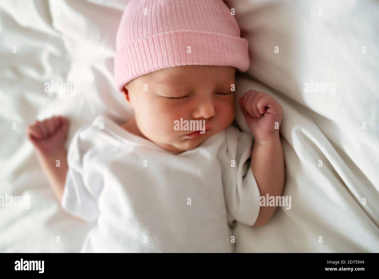 A Sweet newborn baby girl sleeping in white bed Stock Photo - Alamy