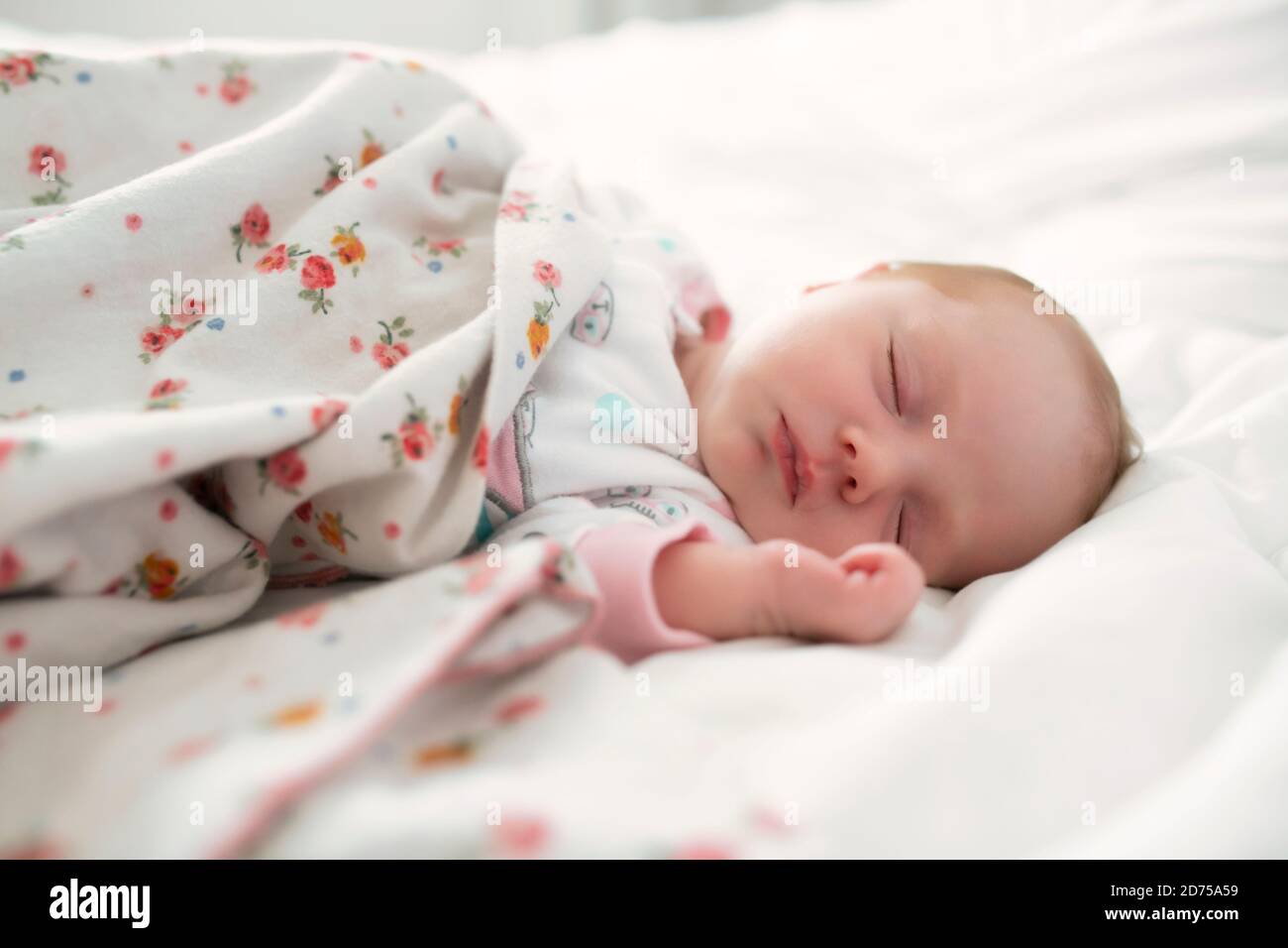 A Sweet newborn baby girl sleeping in white bed Stock Photo - Alamy