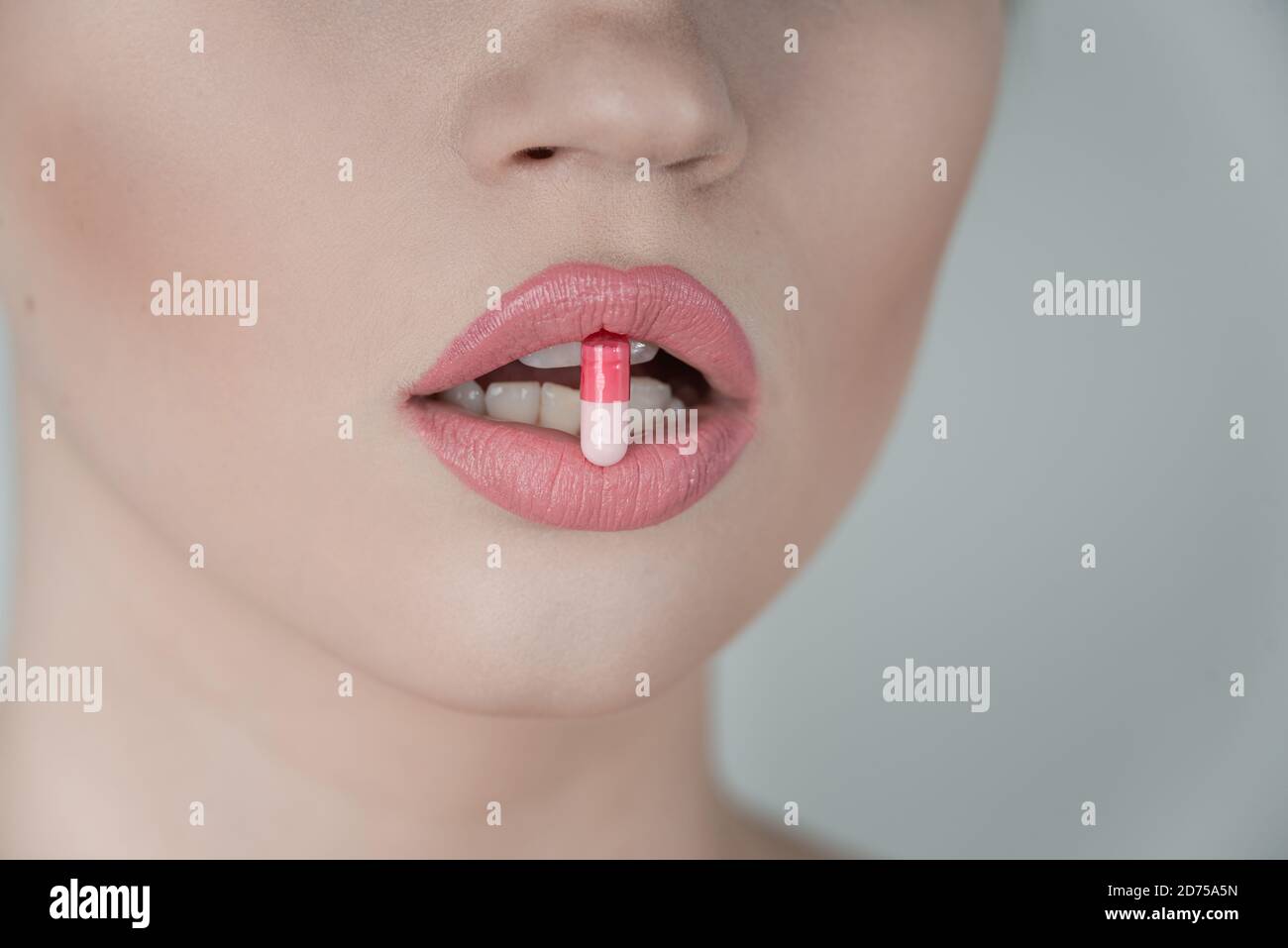 Pill between lips. Close up young woman with medicine pill in her ...