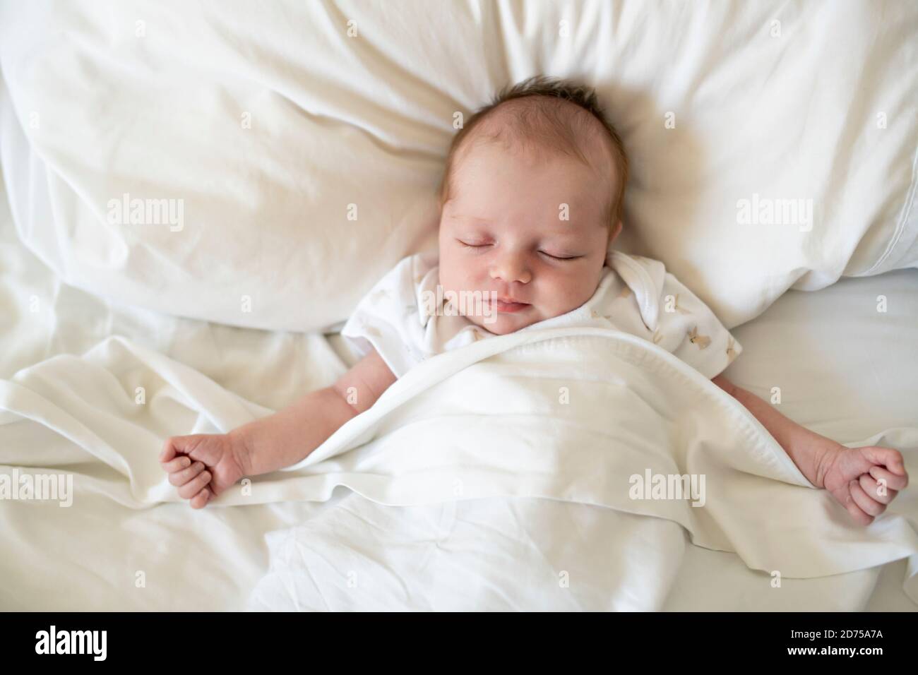 A Sweet newborn baby girl sleeping in white bed Stock Photo - Alamy