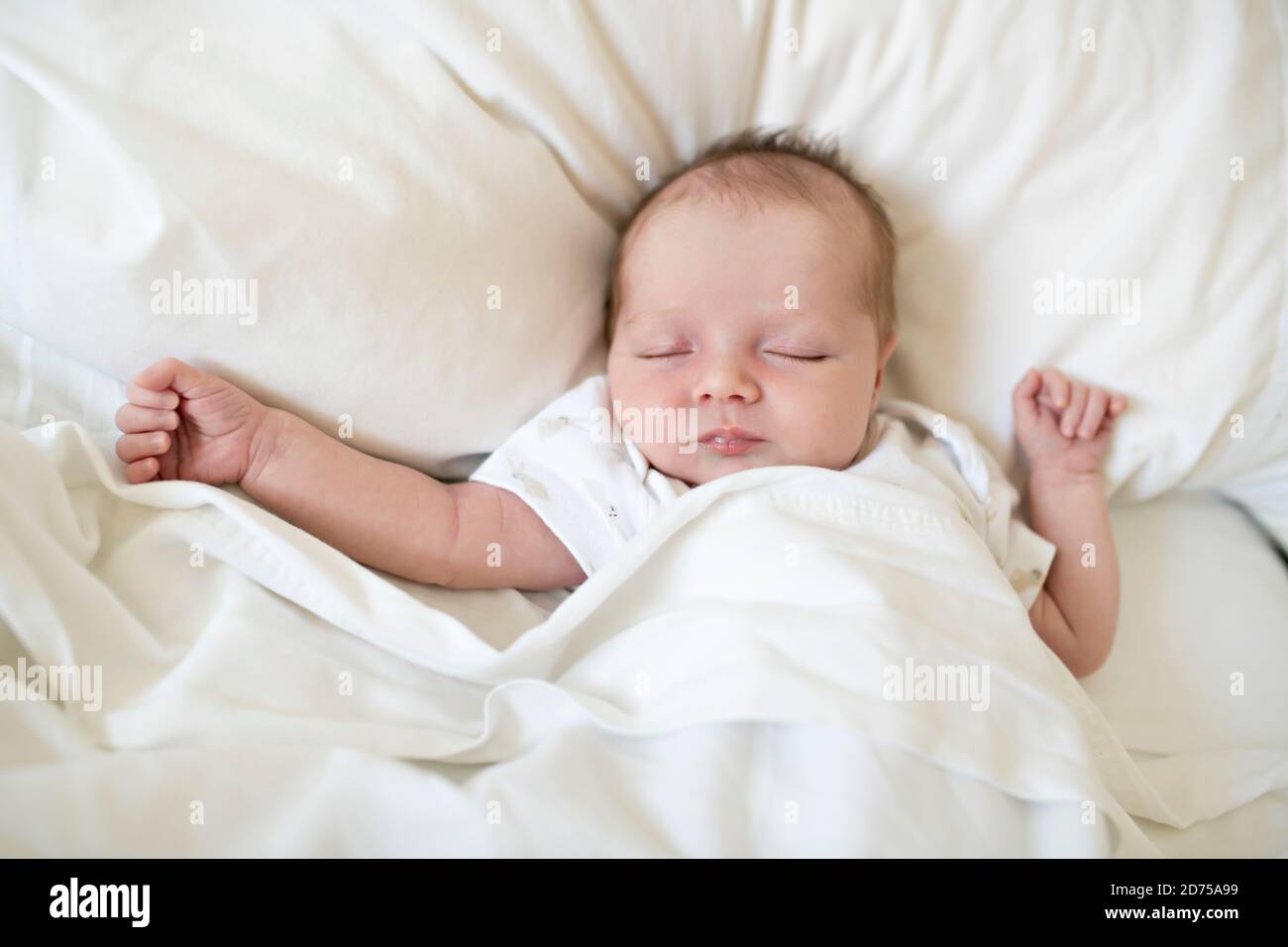 A Sweet newborn baby girl sleeping in white bed Stock Photo - Alamy