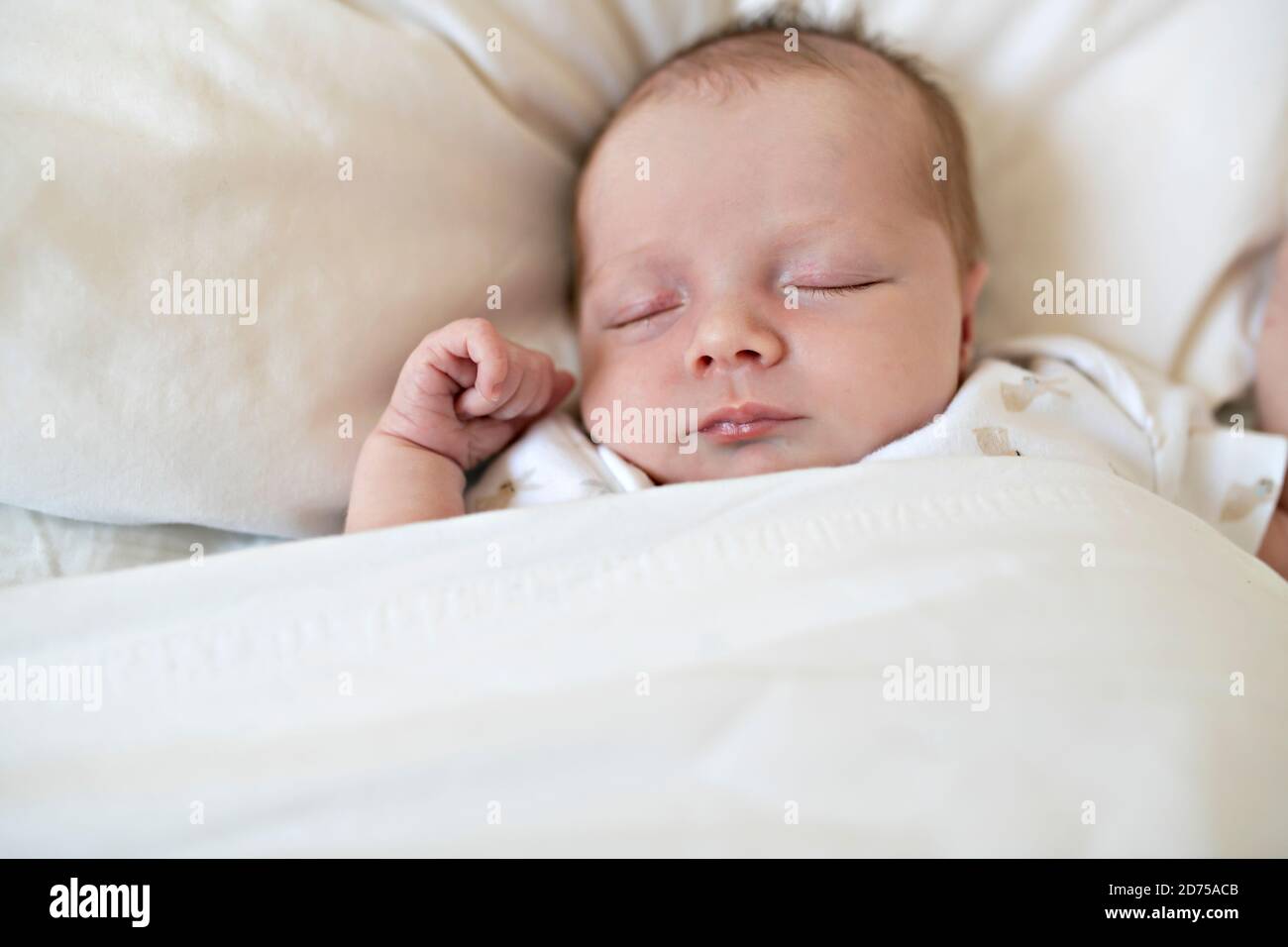 A Sweet newborn baby girl sleeping in white bed Stock Photo - Alamy