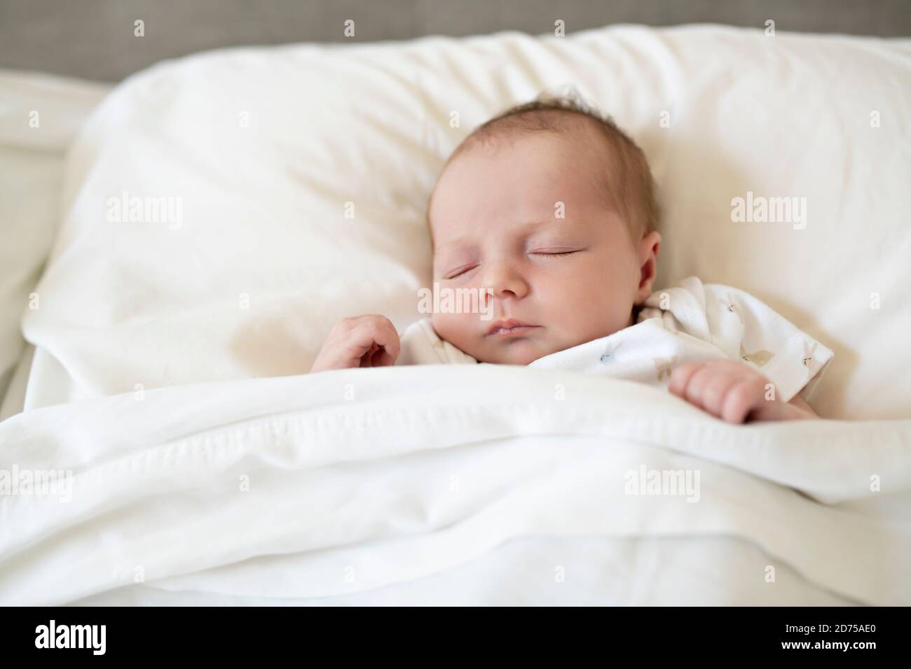 A Sweet newborn baby girl sleeping in white bed Stock Photo - Alamy