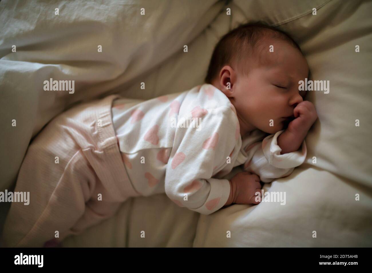 A Sweet newborn baby girl sleeping in white bed Stock Photo - Alamy
