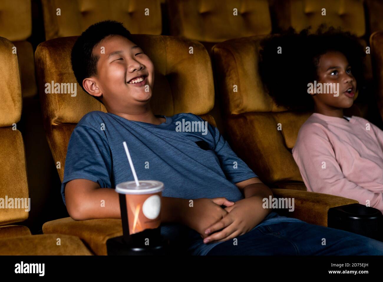 Three children having fun and enjoy watching movie in cinema Stock ...