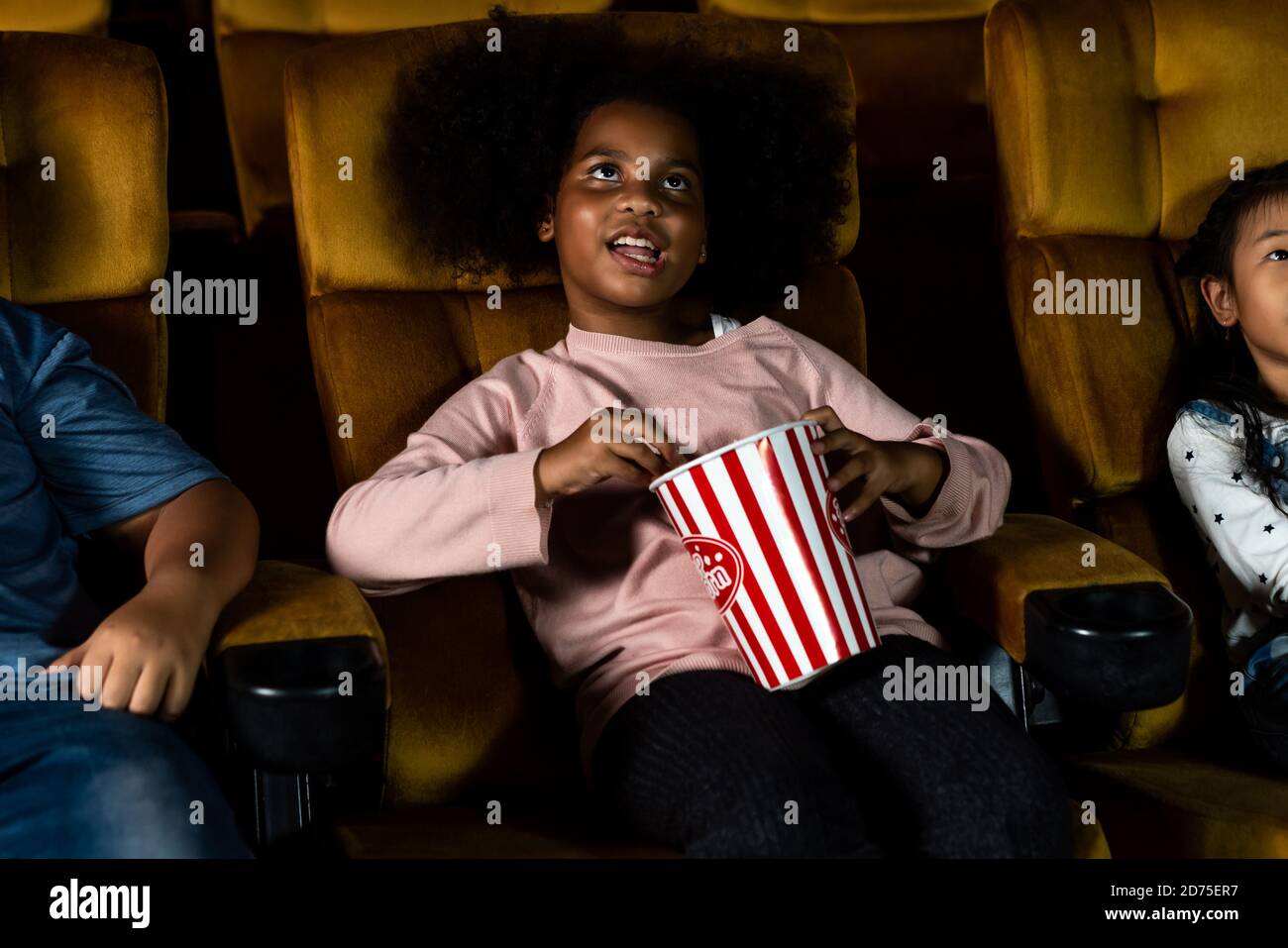 Three children having fun and enjoy watching movie in cinema Stock ...