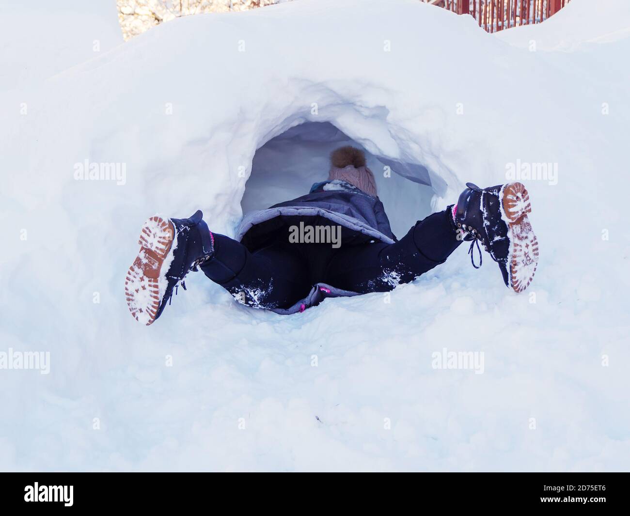 Girl crawling on her stomach in a narrow snow tunnel Stock Photo - Alamy