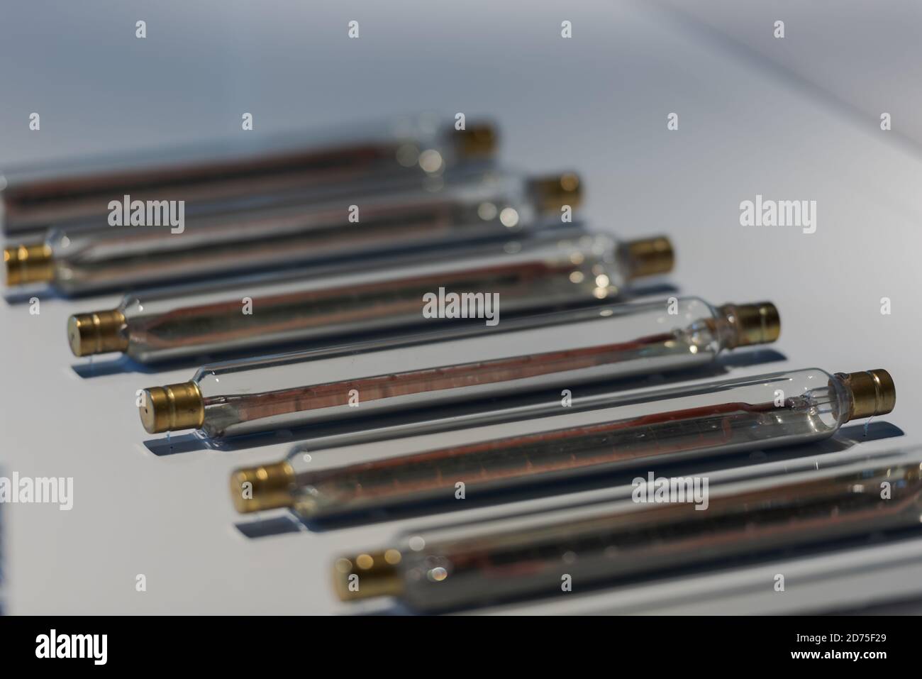 Old long light bulbs in form of tubes lying on white table Stock Photo ...