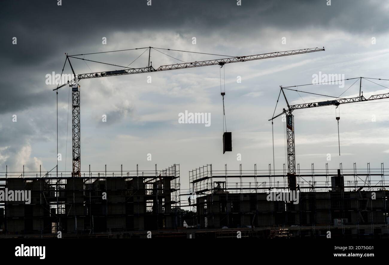 Construction cranes on a building site, shell of a residential building ...