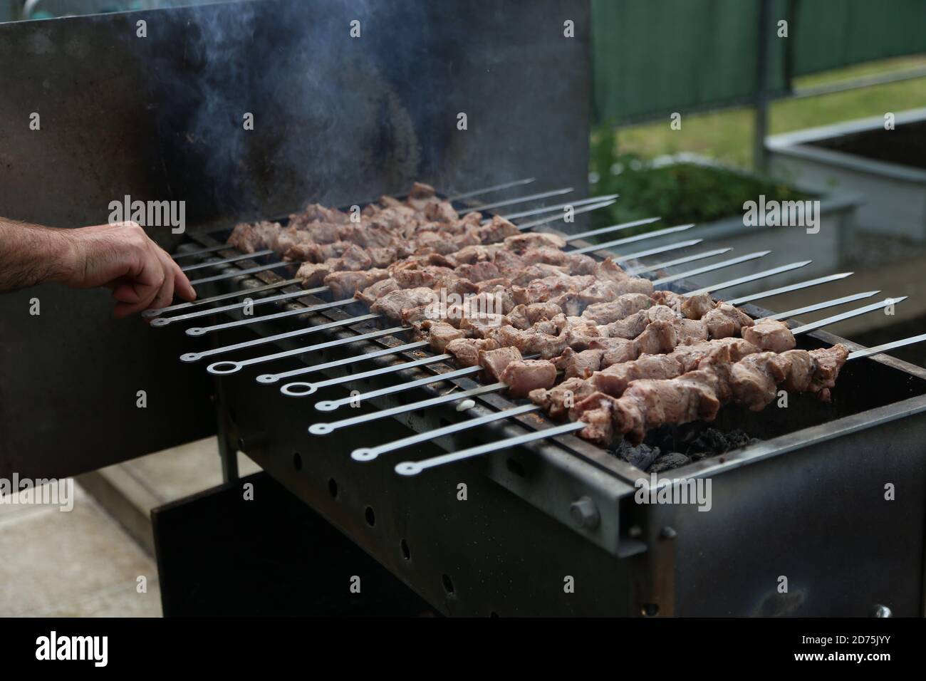 Closeup shot of pork meat with metal skewers on a grill Stock Photo - Alamy