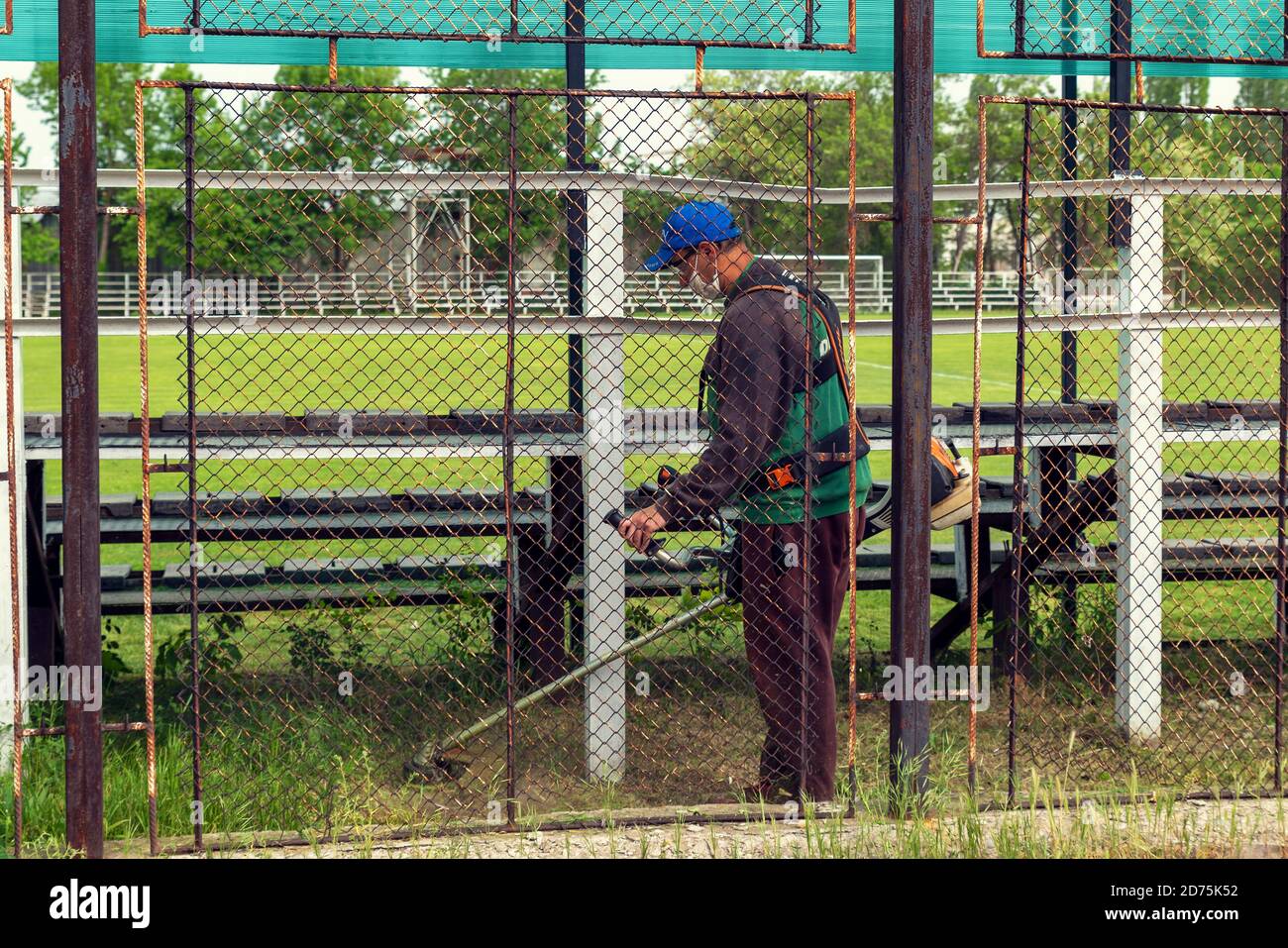 15 May 2020, Sofia, Bulgaria. man cutting grass at a sport stadium and ...