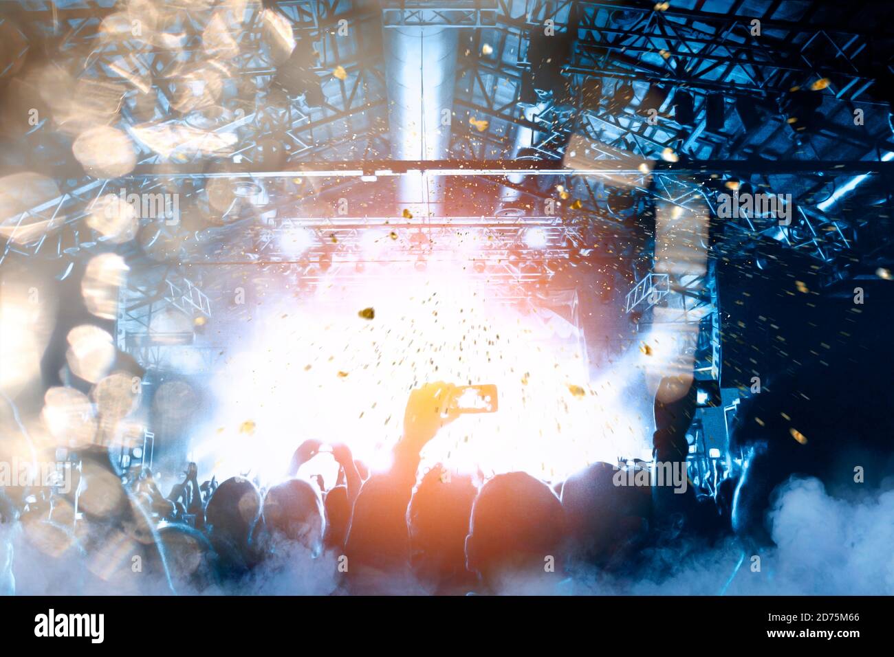 Large assembly of people in front of a large stage lit in the dark ...