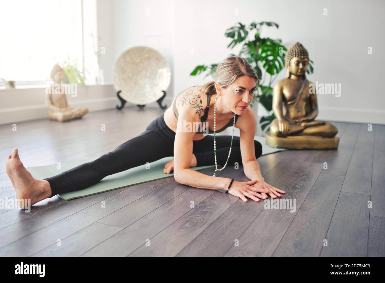 Nice yoga teacher woman in a studio indoors Stock Photo - Alamy