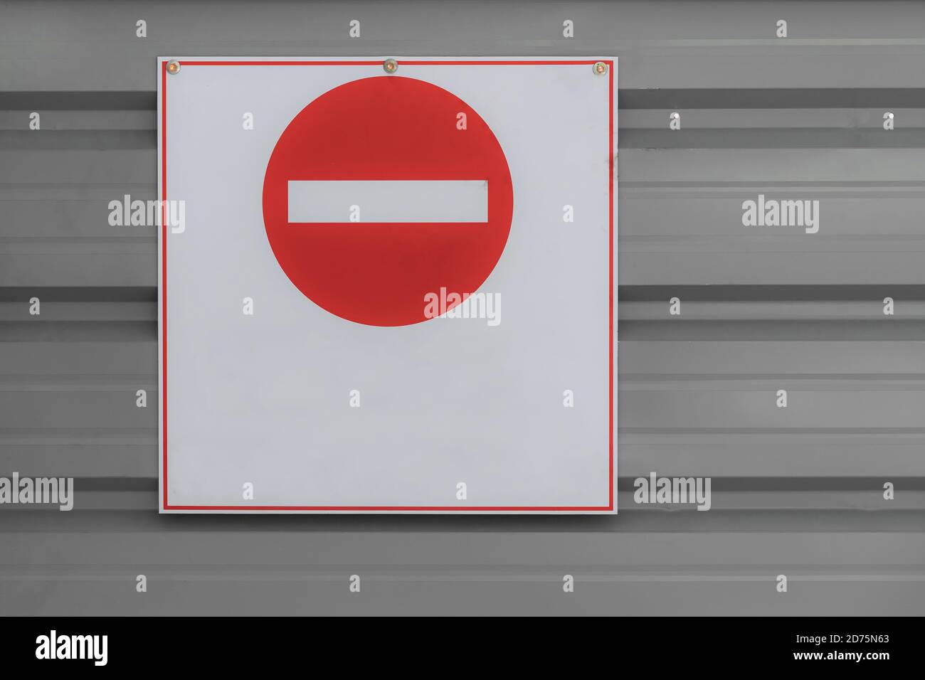 Round red and white "Do not enter" stop sign on a plate against a gray ...
