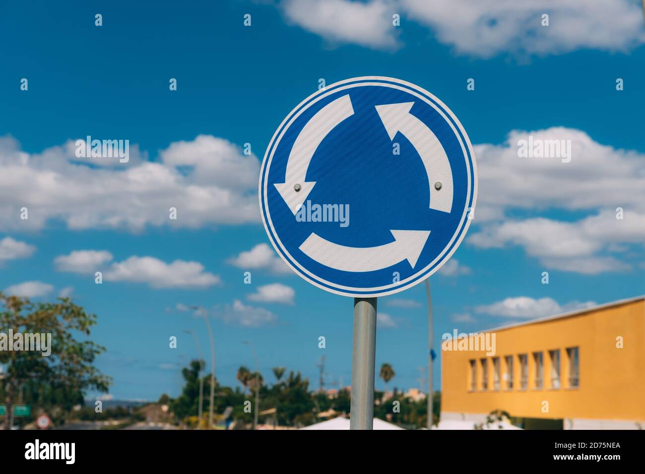 Close-up view of blue and white roundabout sign on the street with ...