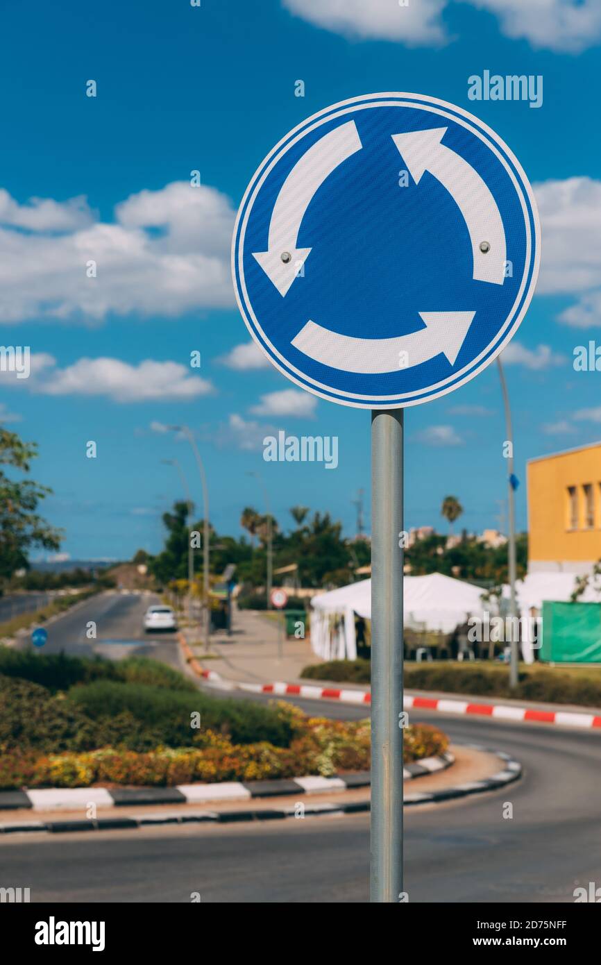 Close-up view of blue and white roundabout sign on the street with ...