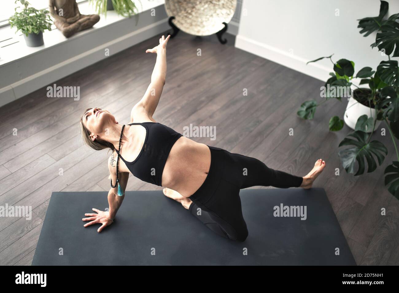 Nice yoga teacher woman in a studio indoors Stock Photo - Alamy