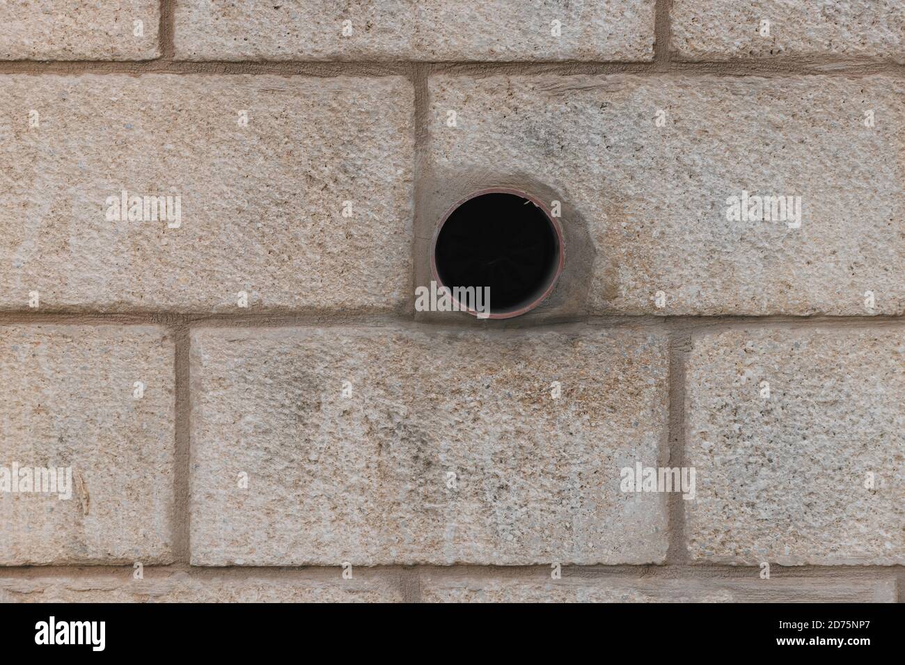 Round hole in the wall. Downpipe from the wall in Israel. Round pipe ...