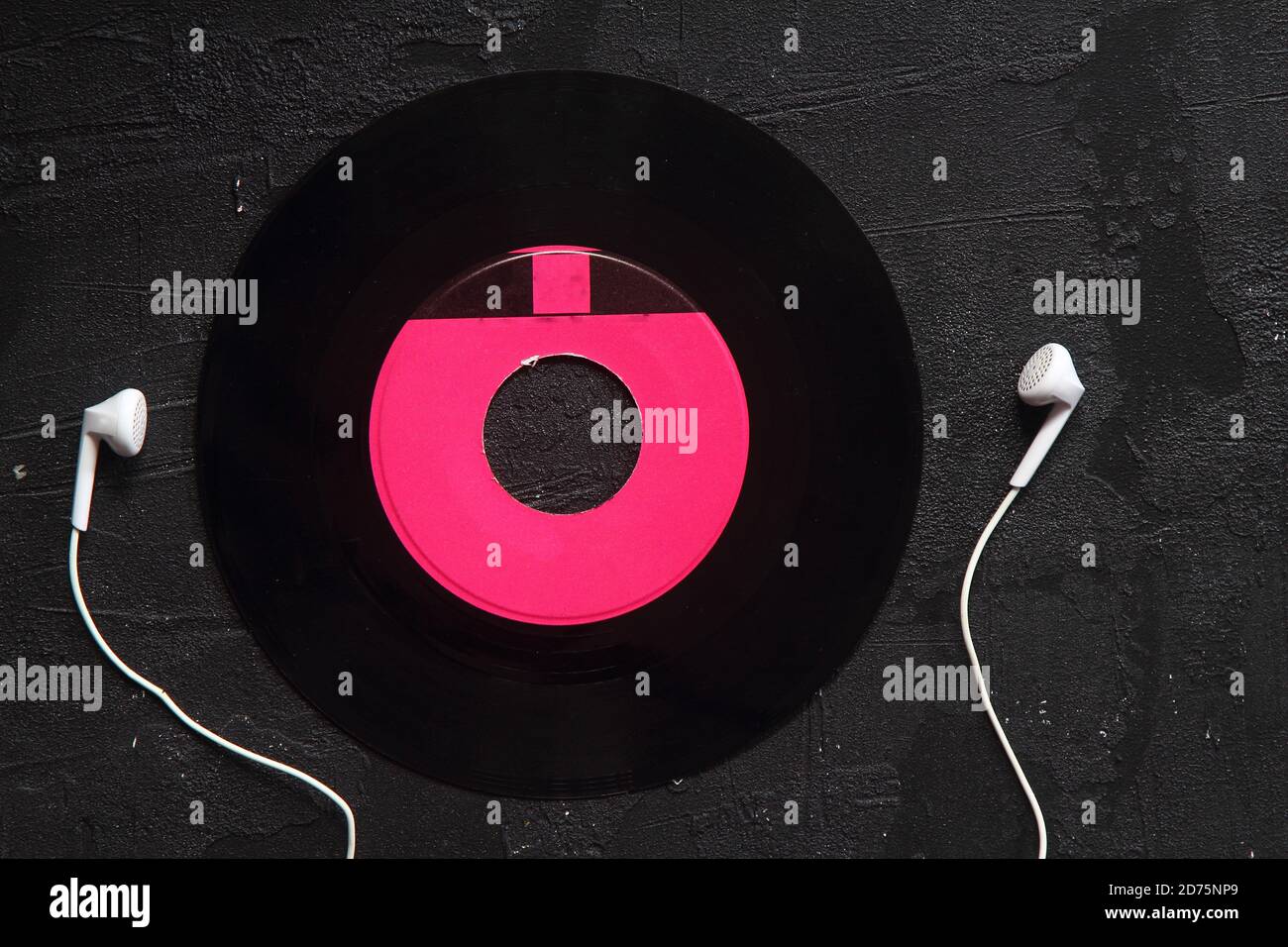 White headphones with wire and vinyl discs on an black background ...