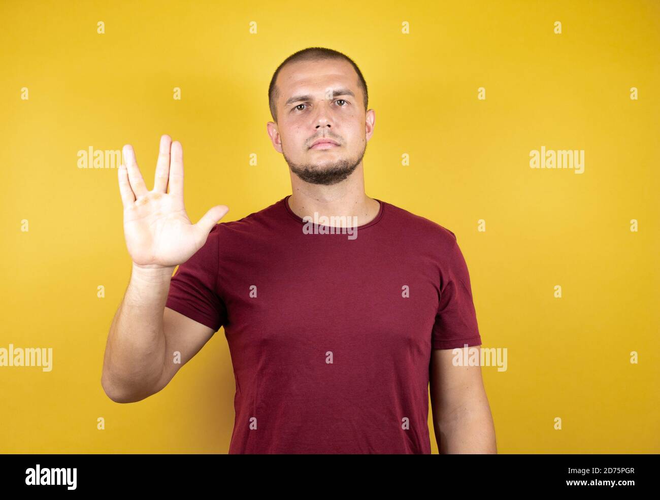 Russian man wearing basic red t-shirt over yellow insolated background ...