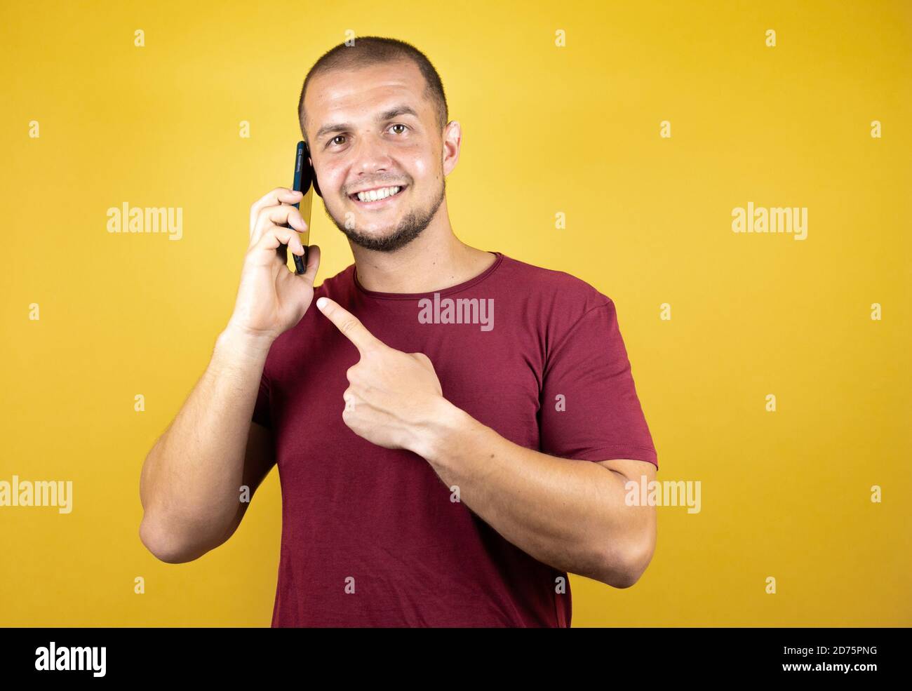 Russian man wearing basic red t-shirt over yellow insolated background ...