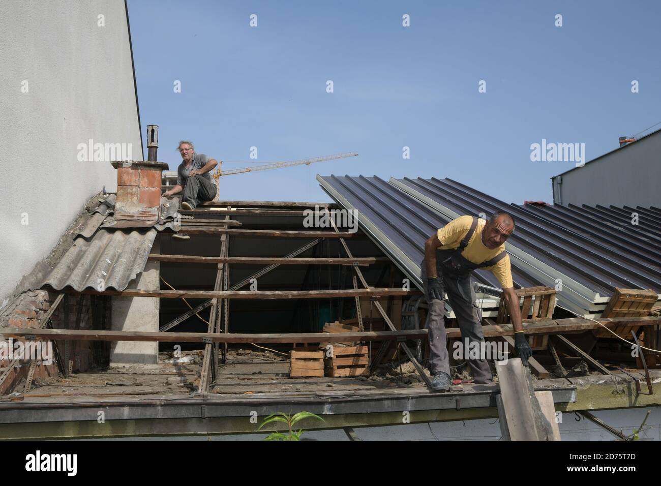 Two workers roofer builder working on roof structure on construction ...