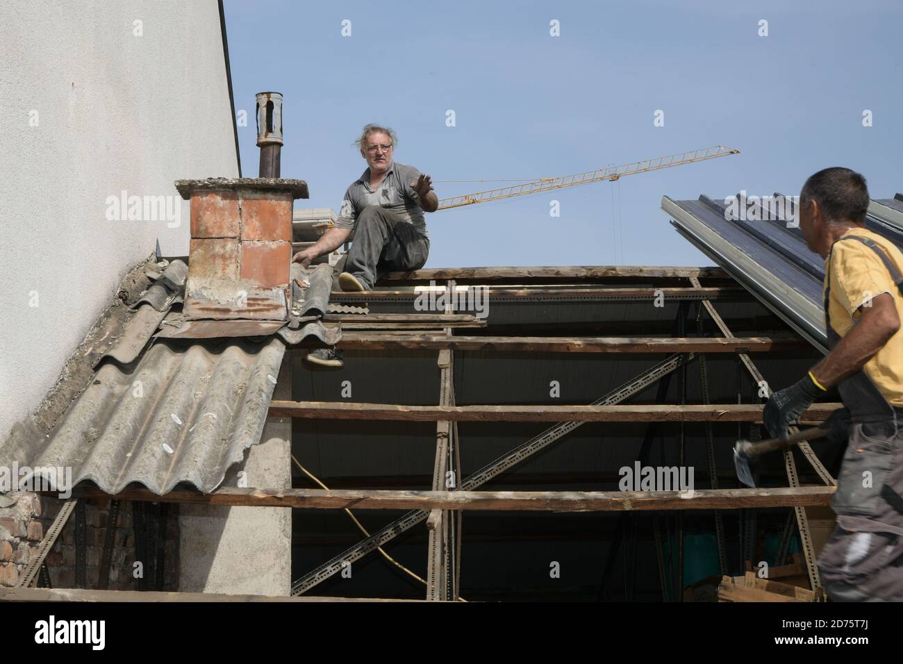 Two workers roofer builder working on roof structure on construction ...