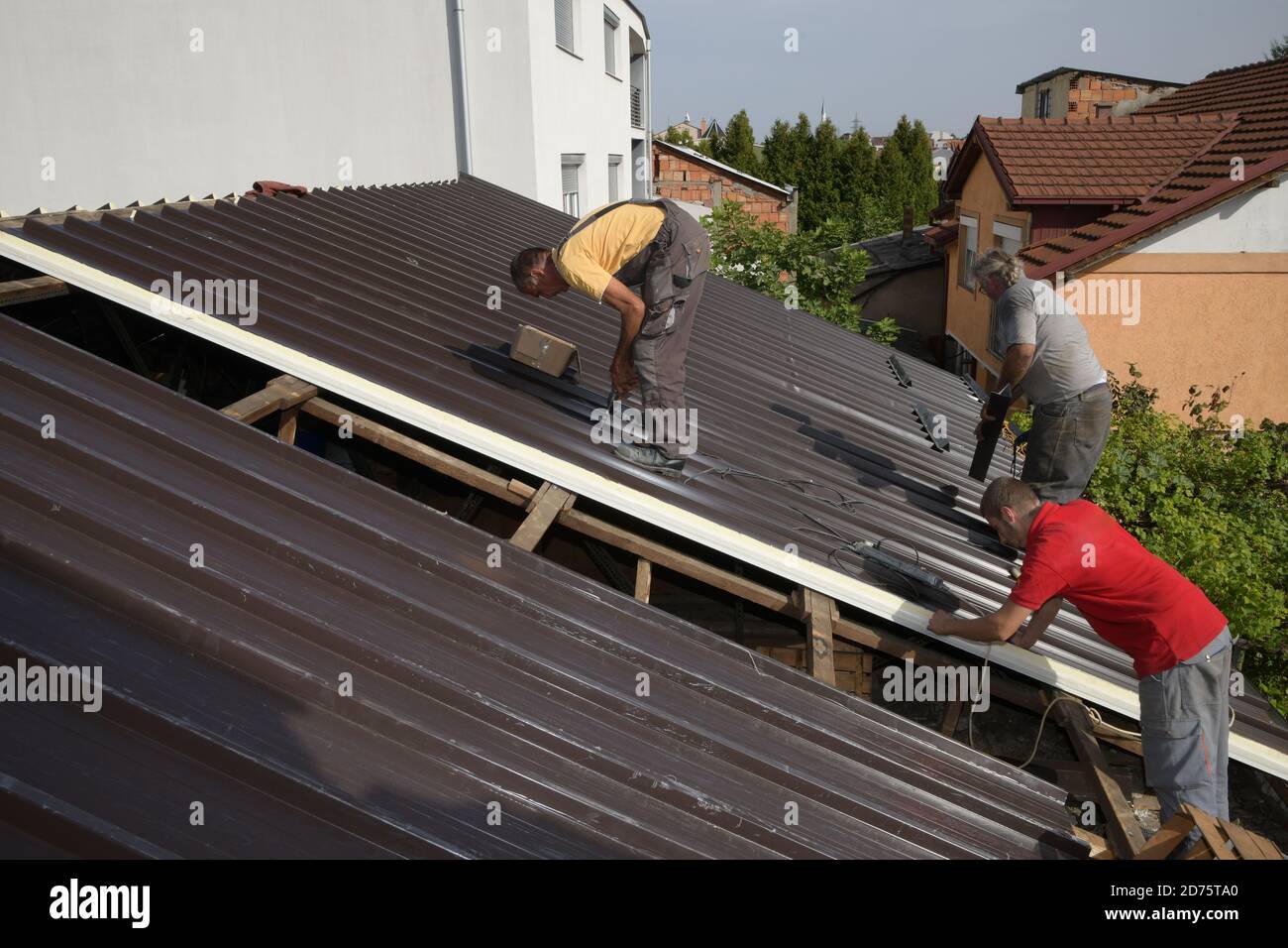 Three workers roofer builder working on roof structure on construction ...