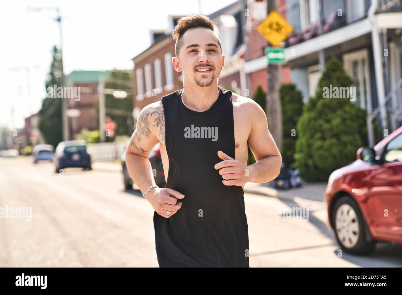 portrait of an athletic young man running and working out in the city ...
