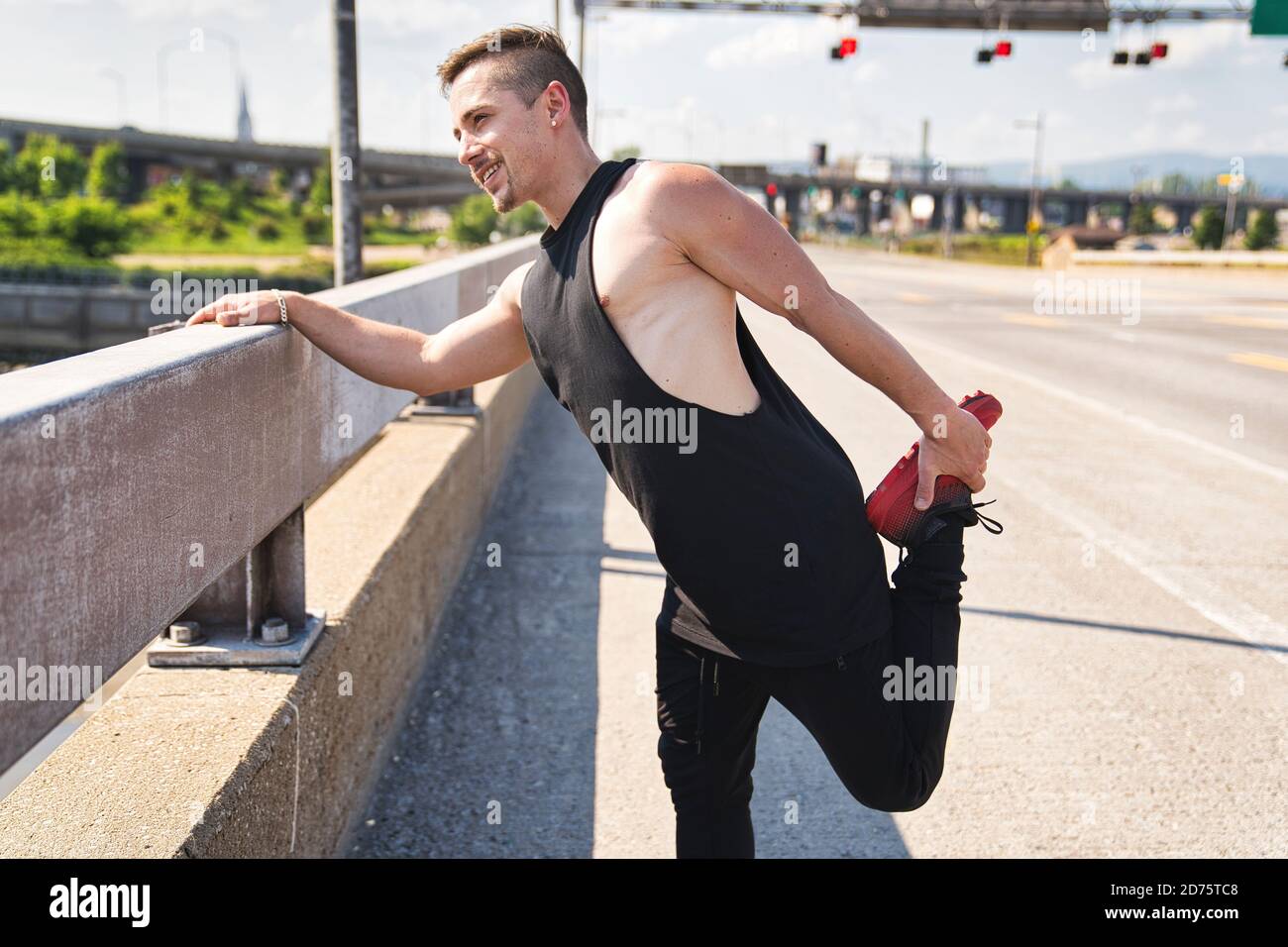 portrait of an athletic young man running and working out in the city ...