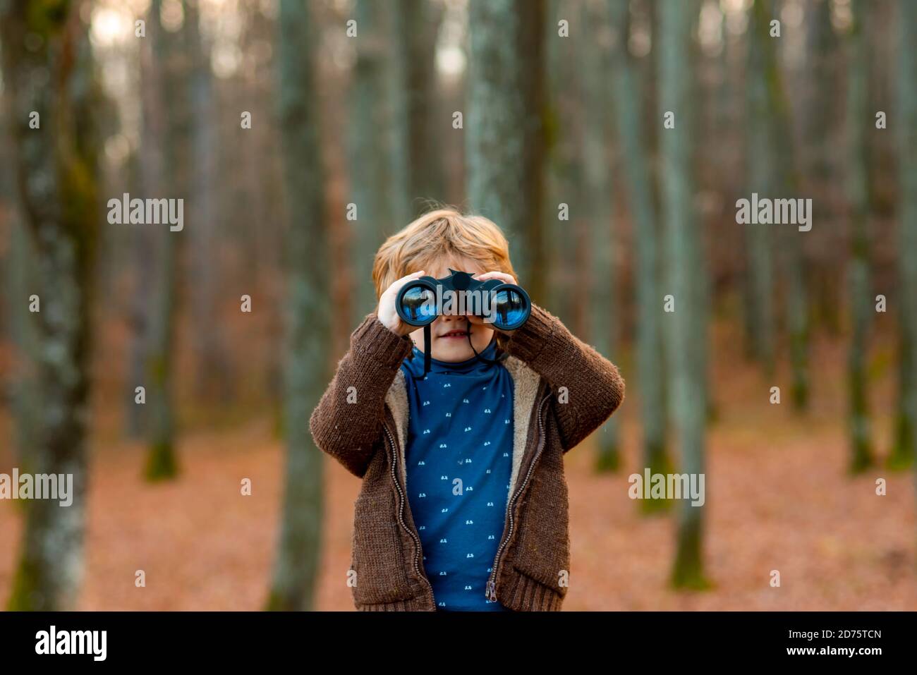Kid looking through binoculars in forest. Child playing outdoors. Kids ...