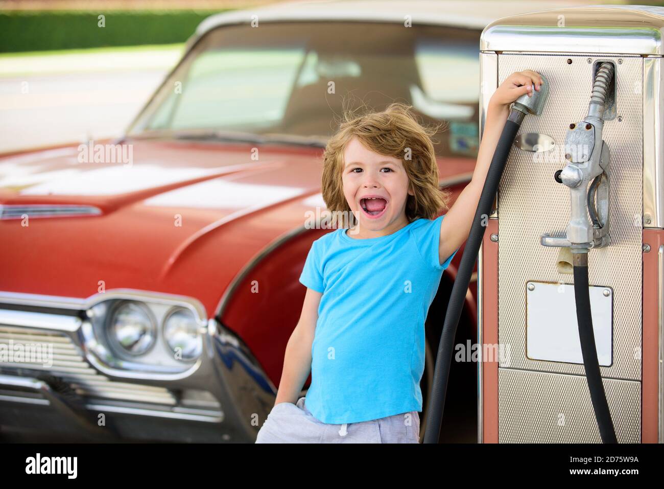 Kid fueling retro car at gas station. Refuel fill up with petrol ...