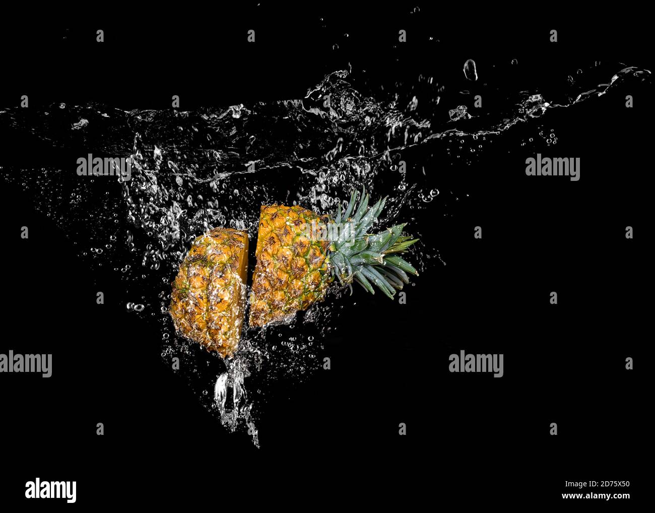 Pineapple falling into water with bubbles on black background Stock ...