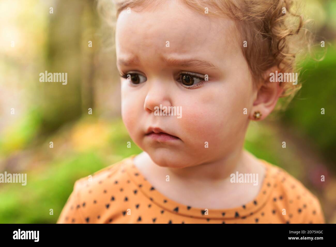 Cute and fashion child girl in autumn park look sad Stock Photo - Alamy