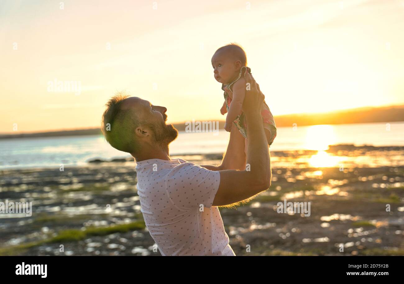 father and baby child girl at the sunset on the waterscape Stock Photo ...